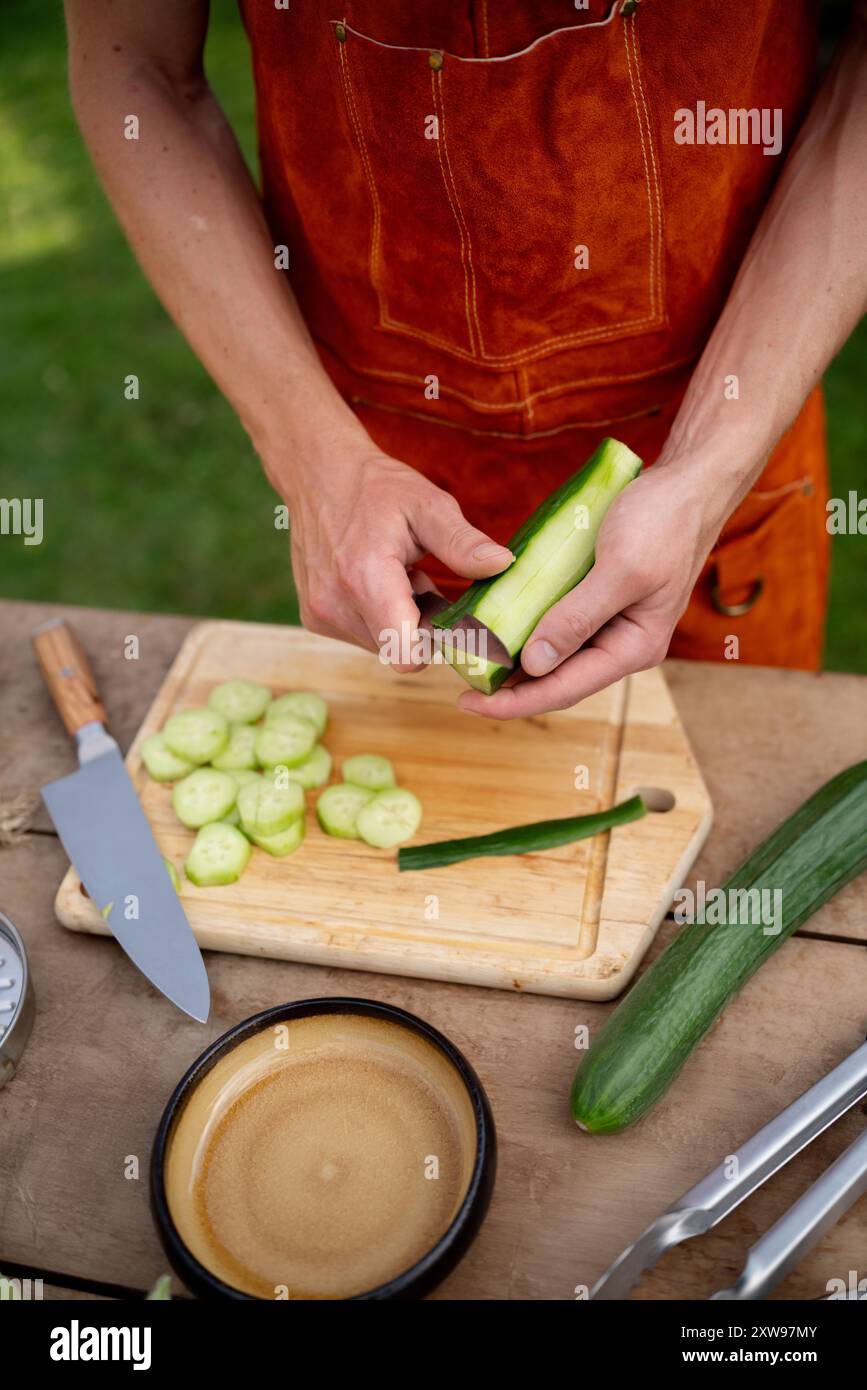 Close up of man holding sharp knife, peeling cucumber. Preparing ...