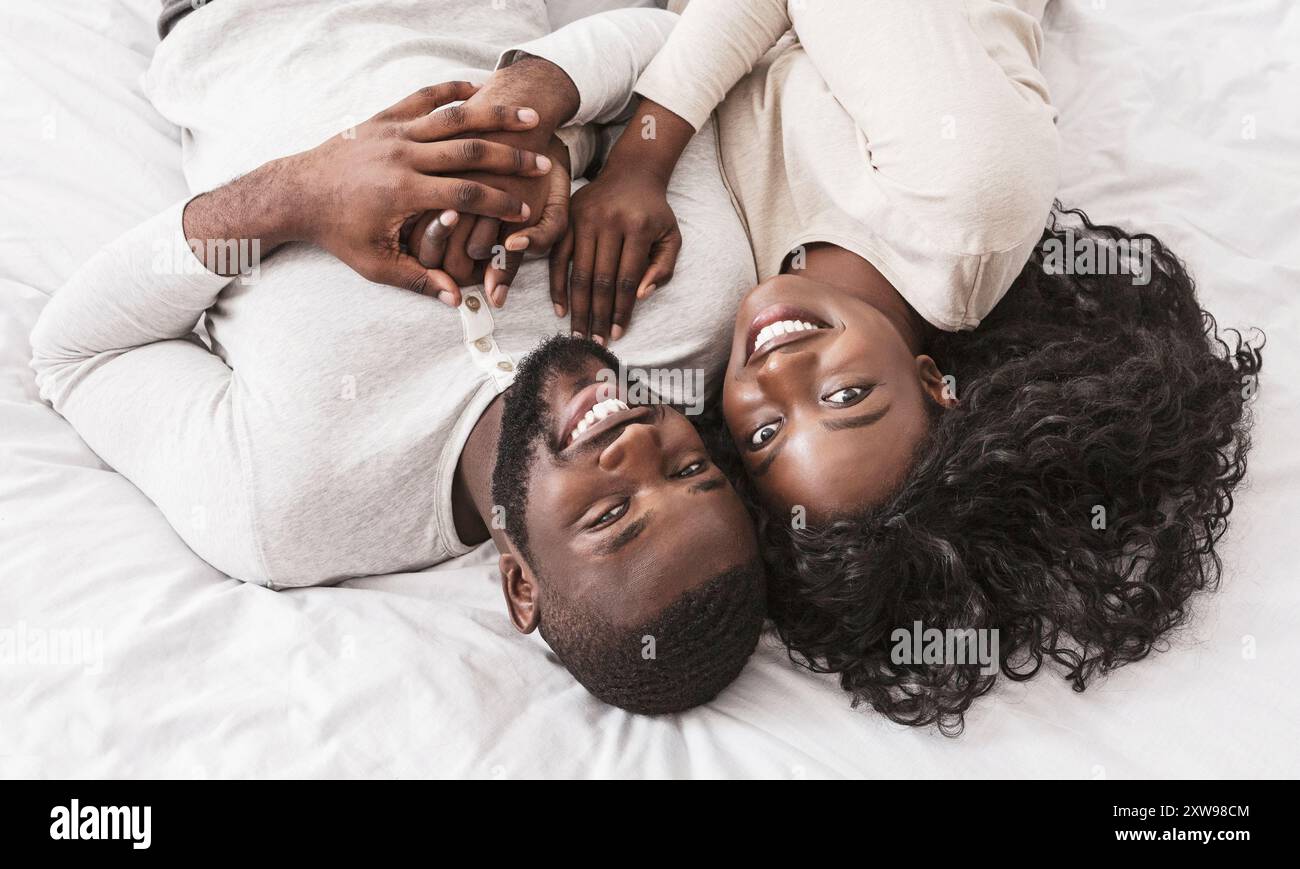 Young african american couple in love lying on bed together Stock Photo ...