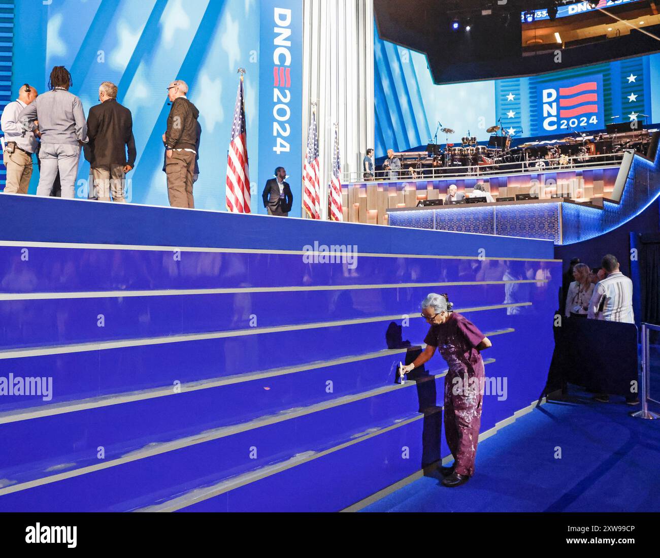 A painter (R) applies a coat of paint to the stage in the United Center ...