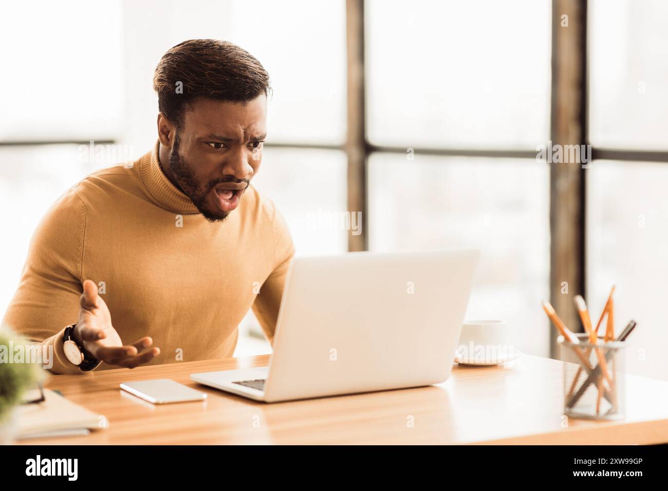 Shocked surprised balck guy using pc at work Stock Photo - Alamy