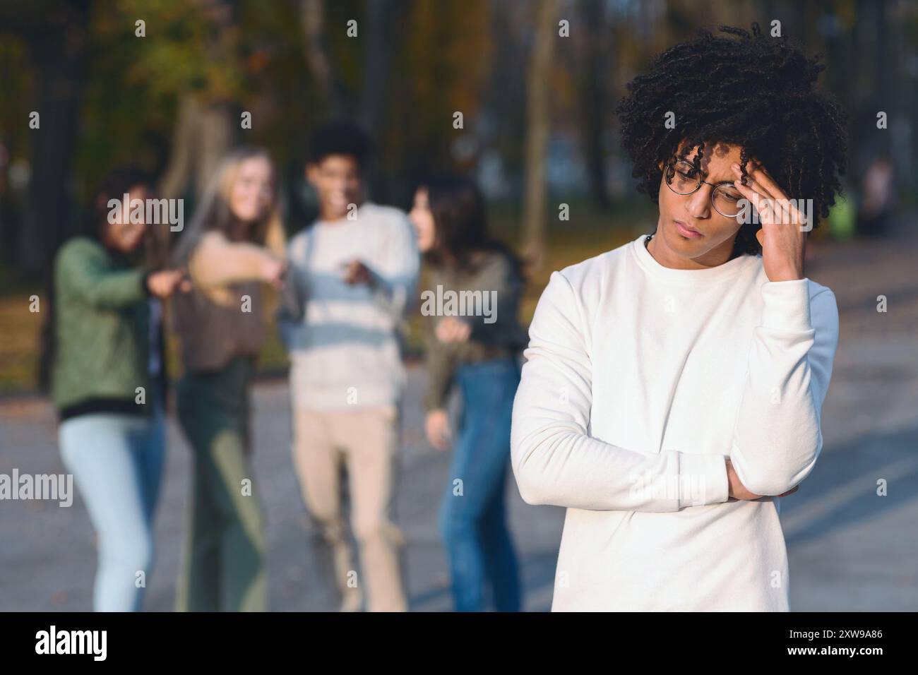Multiracial teenagers pointing at frustrated black guy Stock Photo - Alamy