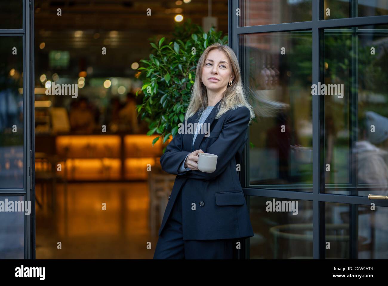 Dreaming smiling businesswoman, receptionist drinking coffee, waiting ...