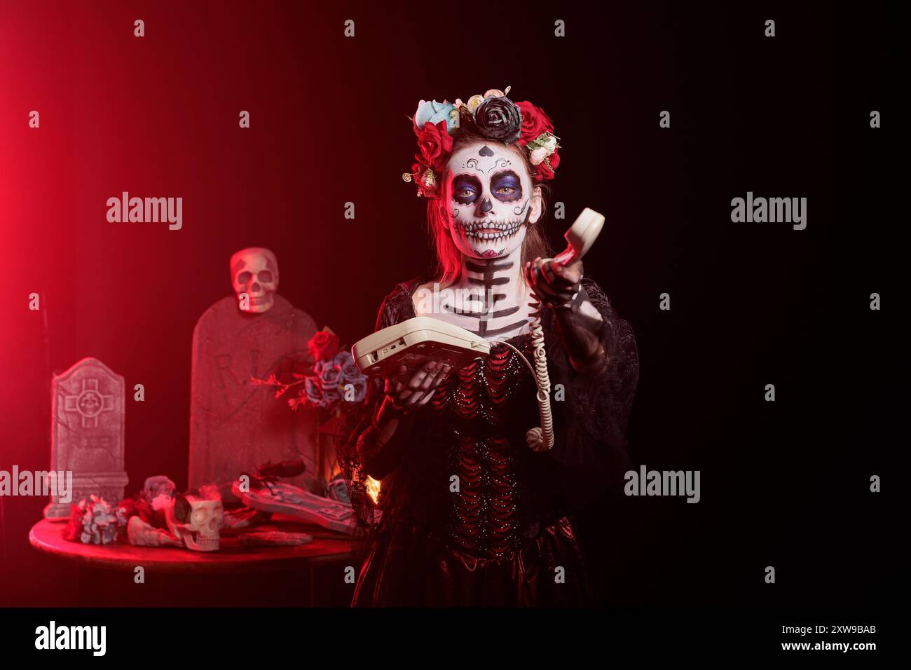 Woman talking on office cord telephone at Day of the Dead event to ...