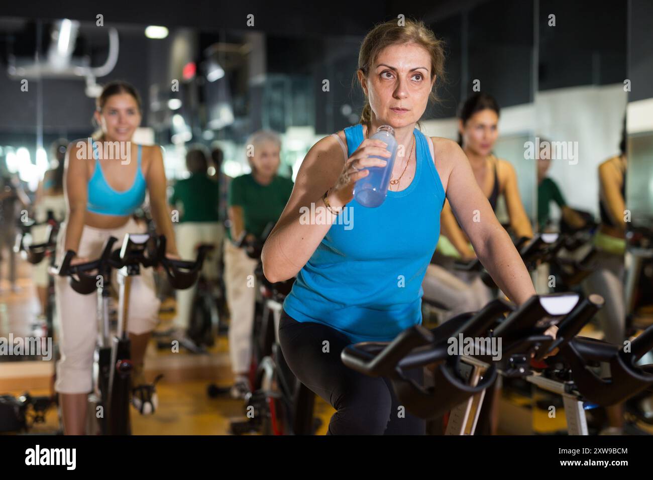 Woman drinking water during workout in gym Stock Photo - Alamy