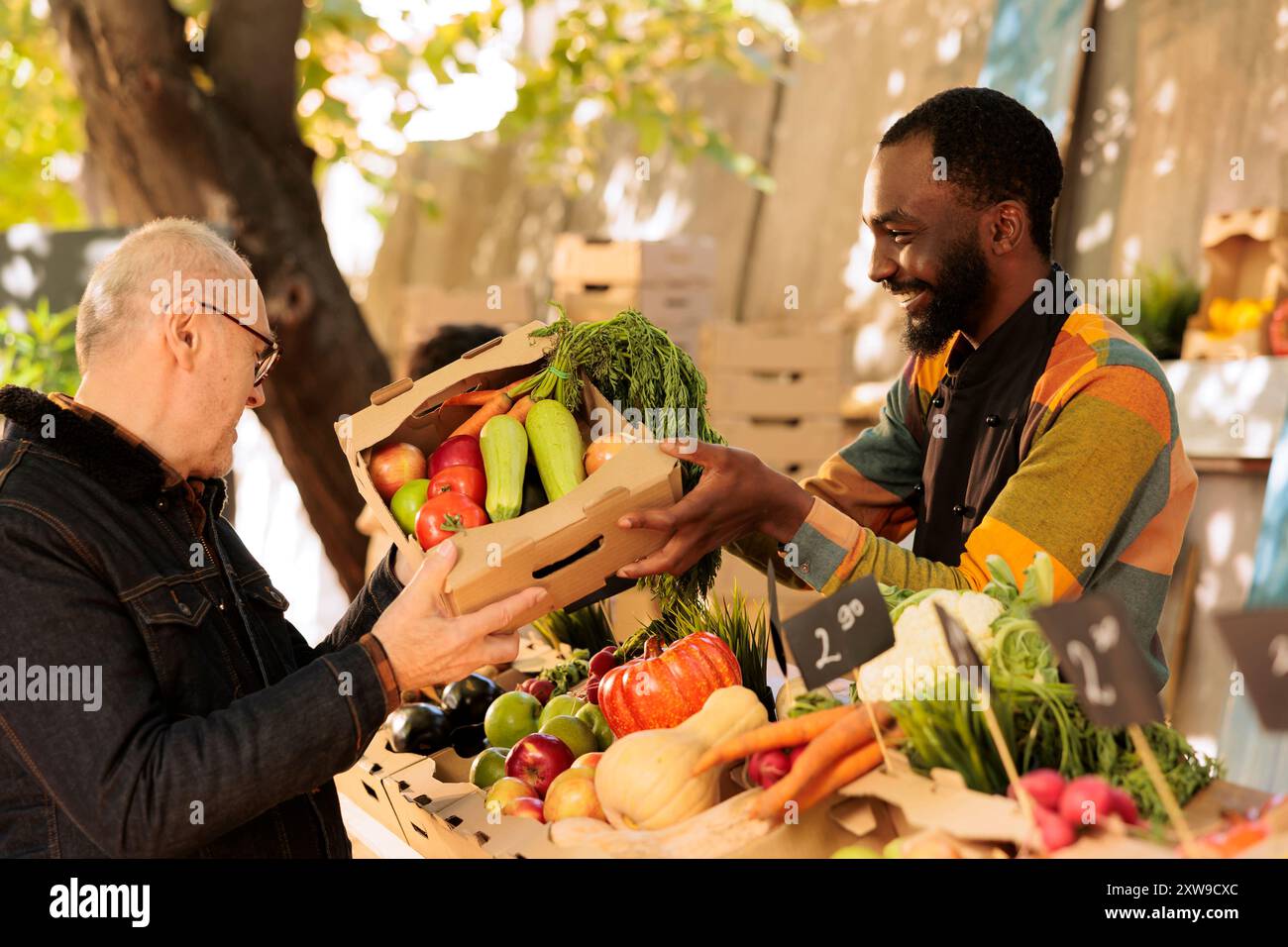 Elderly man buying various seasonal fruits and vegetables at farmers ...