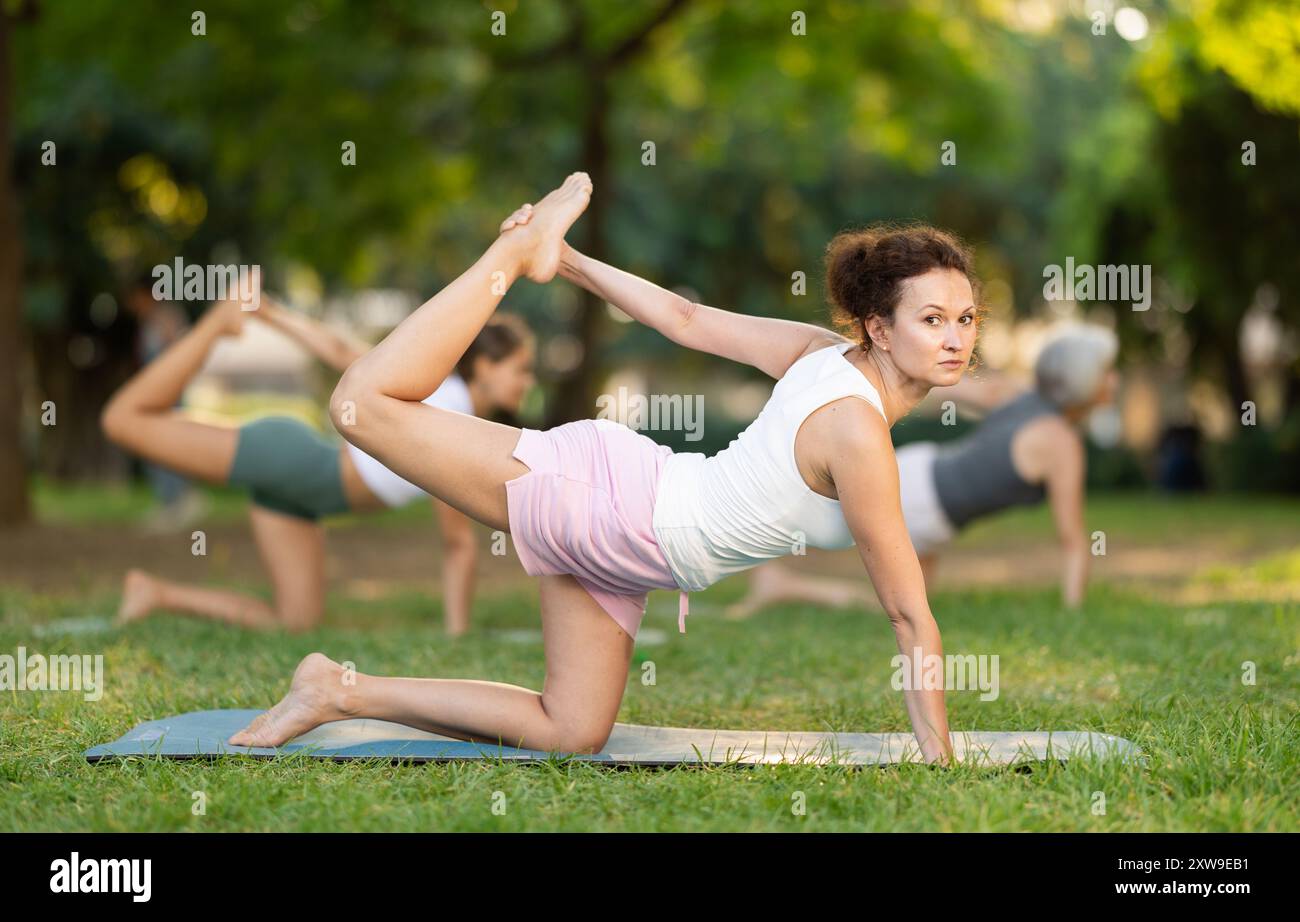 Positive sporty skilled young female teacher demonstrating table pose ...