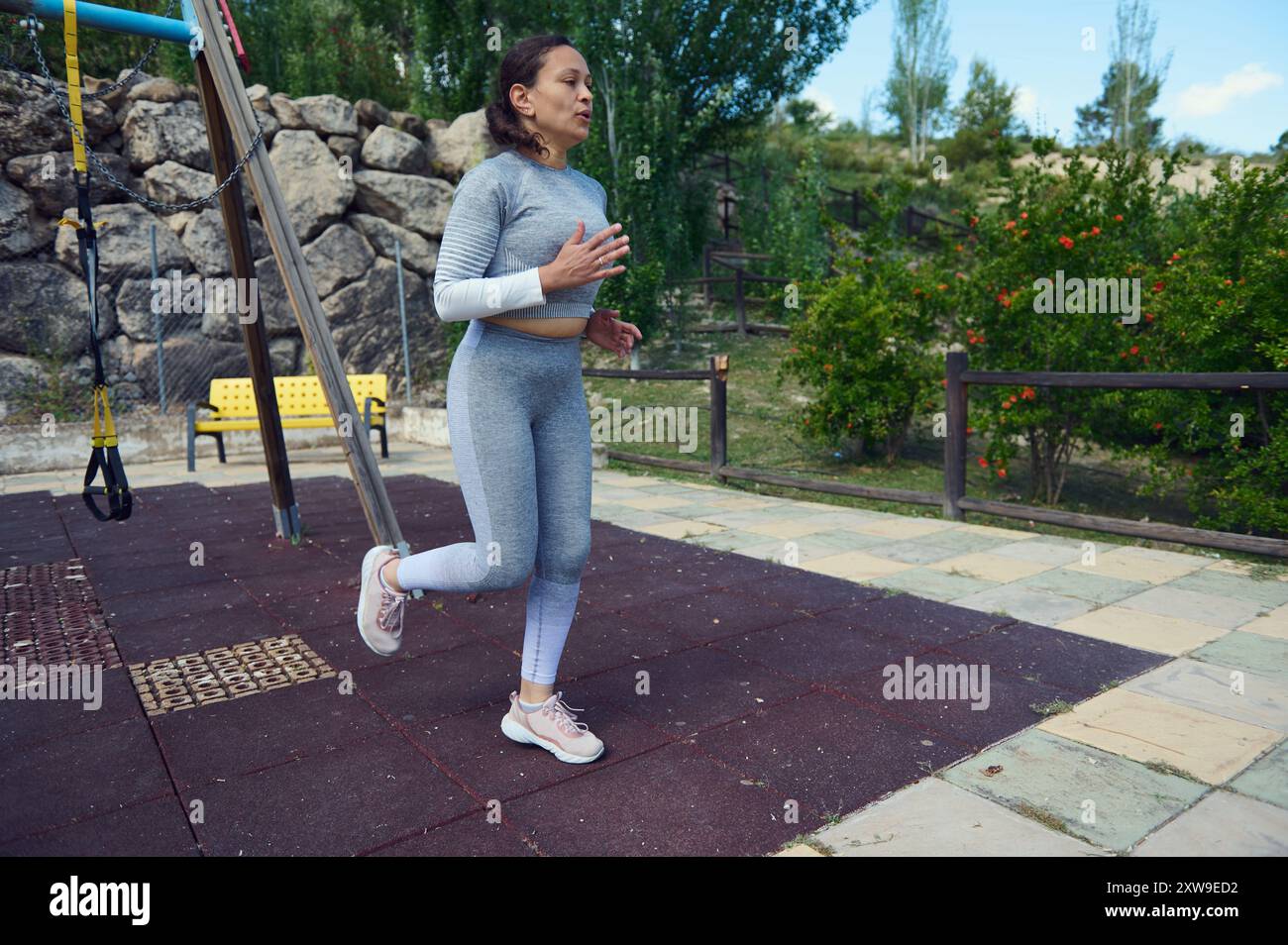 Woman performing outdoor exercise routine in park, showcasing healthy ...