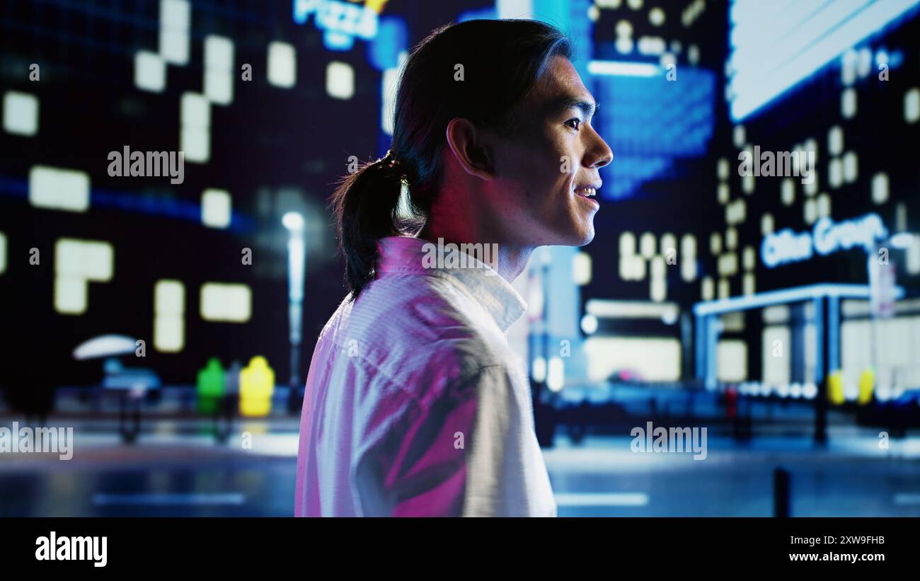 Asian man wandering around city streets at night, looking upwards to ...