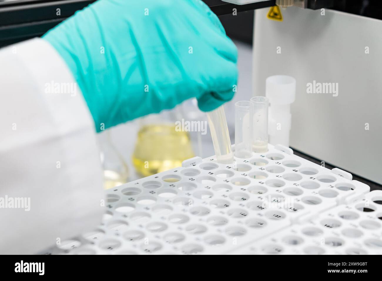 Female hand takes tube from fraction collector connected to HPLC Stock ...