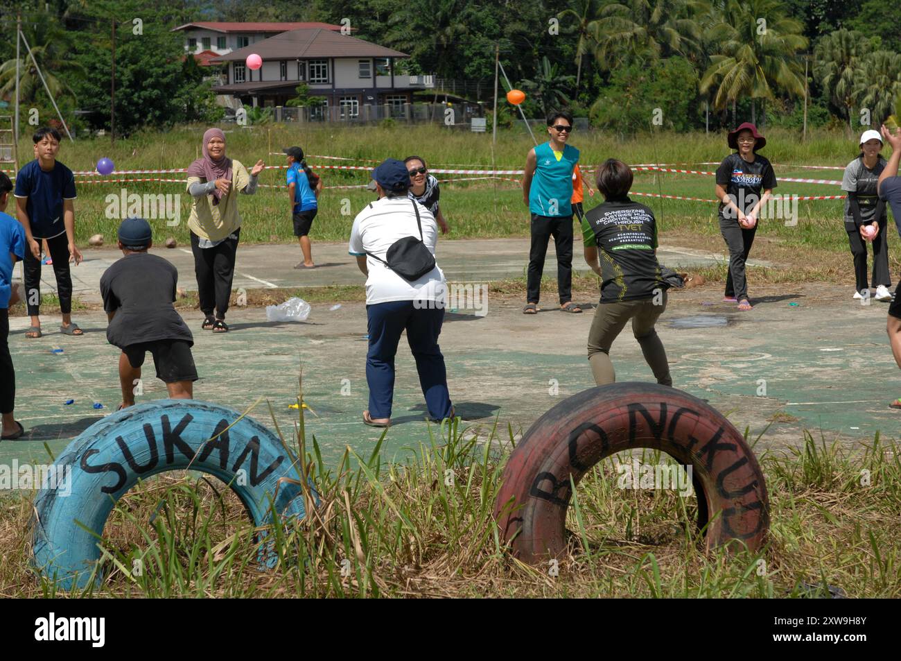 Water balloon catching game, during a community event at Bongkud, Ranau ...