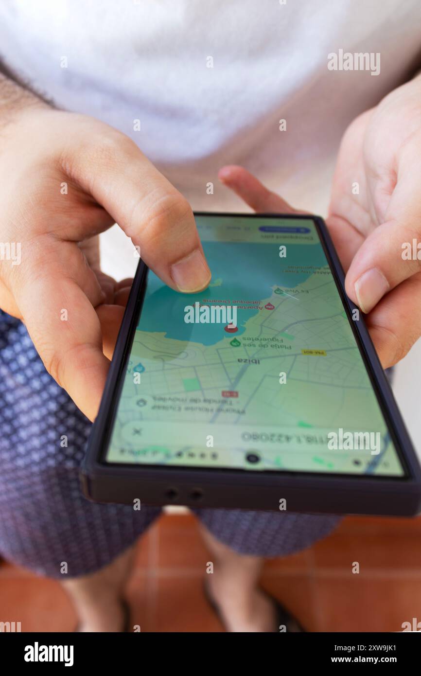 Man navigating a vacation spot with a map on his cell phone, close up ...