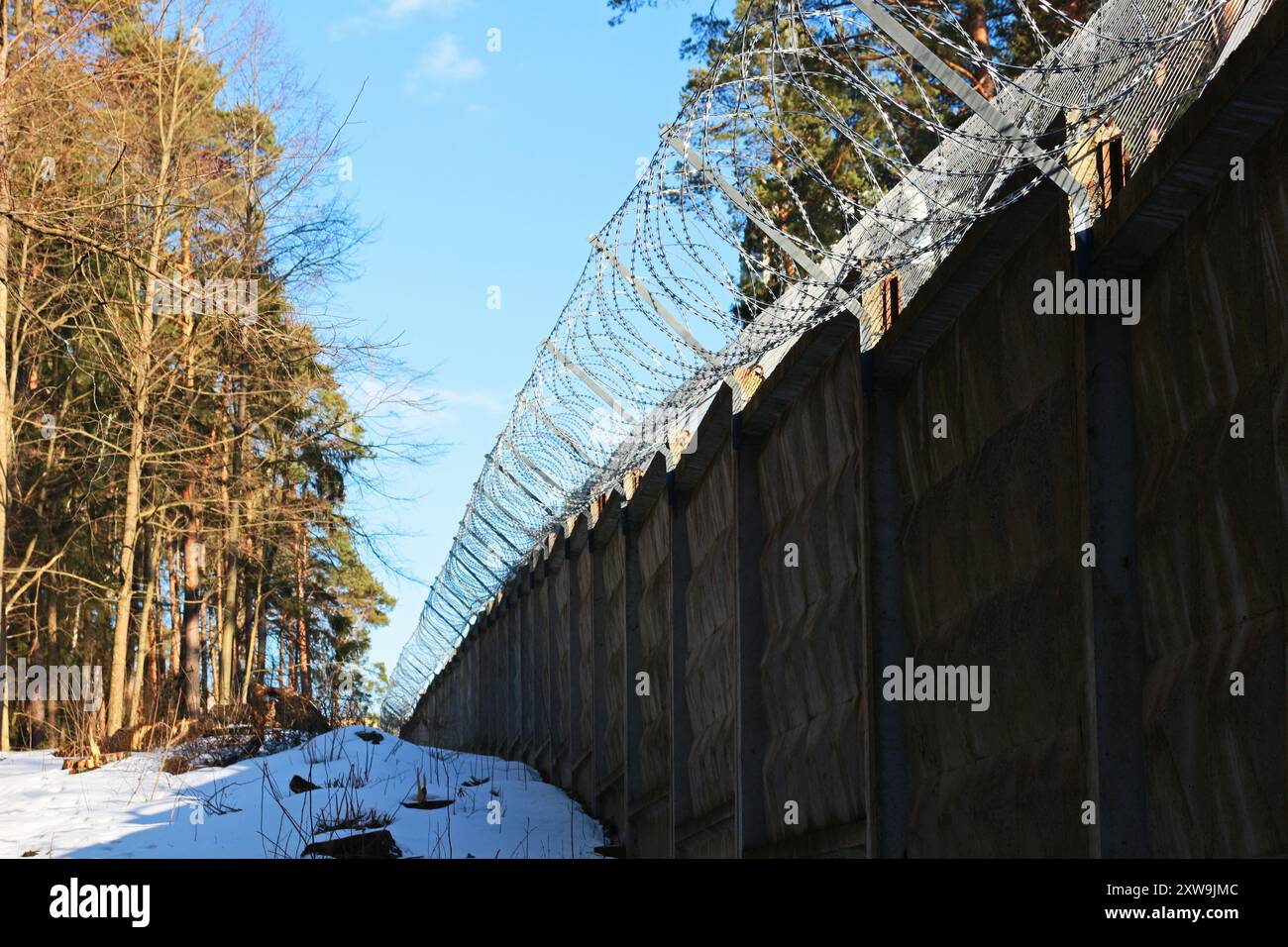 Concrete fence with barbed wire, forbidden zone Stock Photo - Alamy