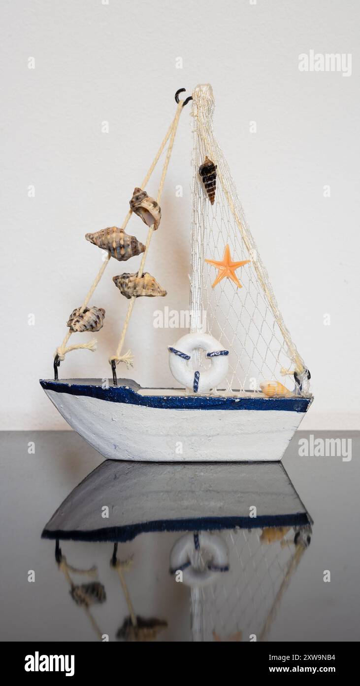 Handmade little white boat with starfish and shells on the sails Stock ...