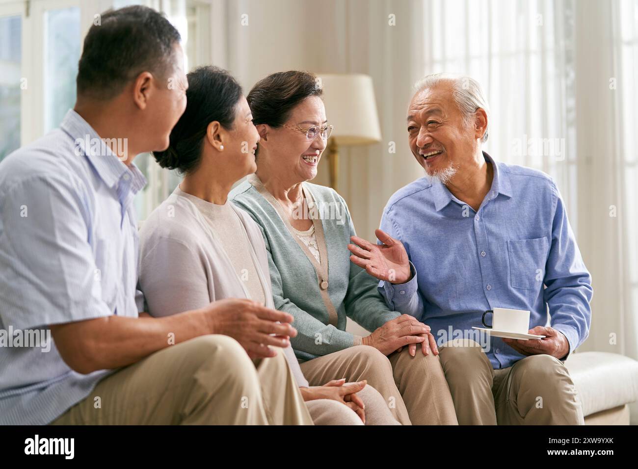 group of happy senior asian people sitting on couch at home having a pleasant conversation Stock ...