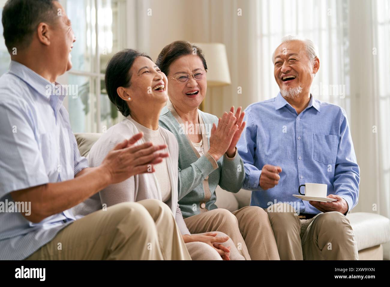 group of happy senior asian people sitting on couch at home having a pleasant conversation Stock ...