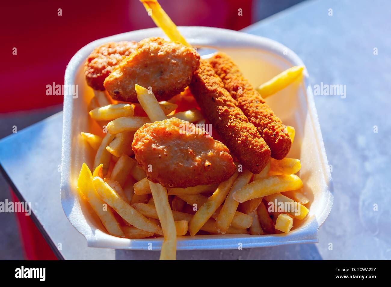 Styrofoam container with a variety of fried foods including chicken ...