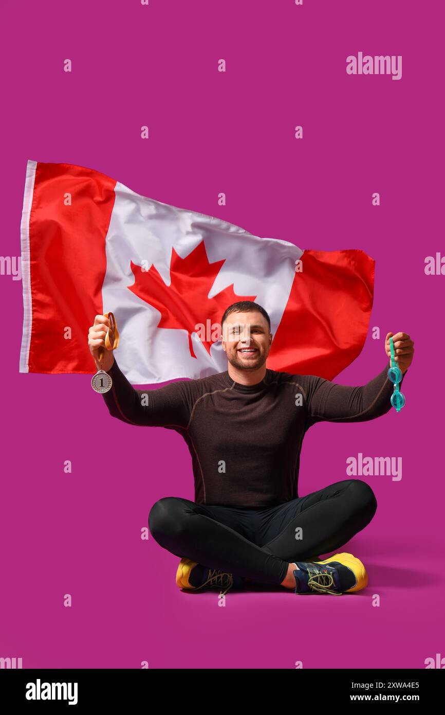 Male swimmer with first place medal sitting against Canadian flag on ...