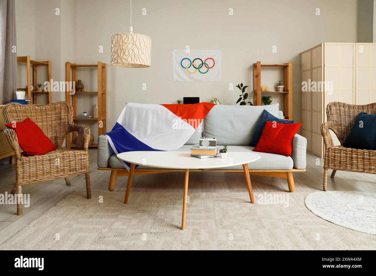 Interior of living room with grey sofa, wicker armchair, coffee table ...