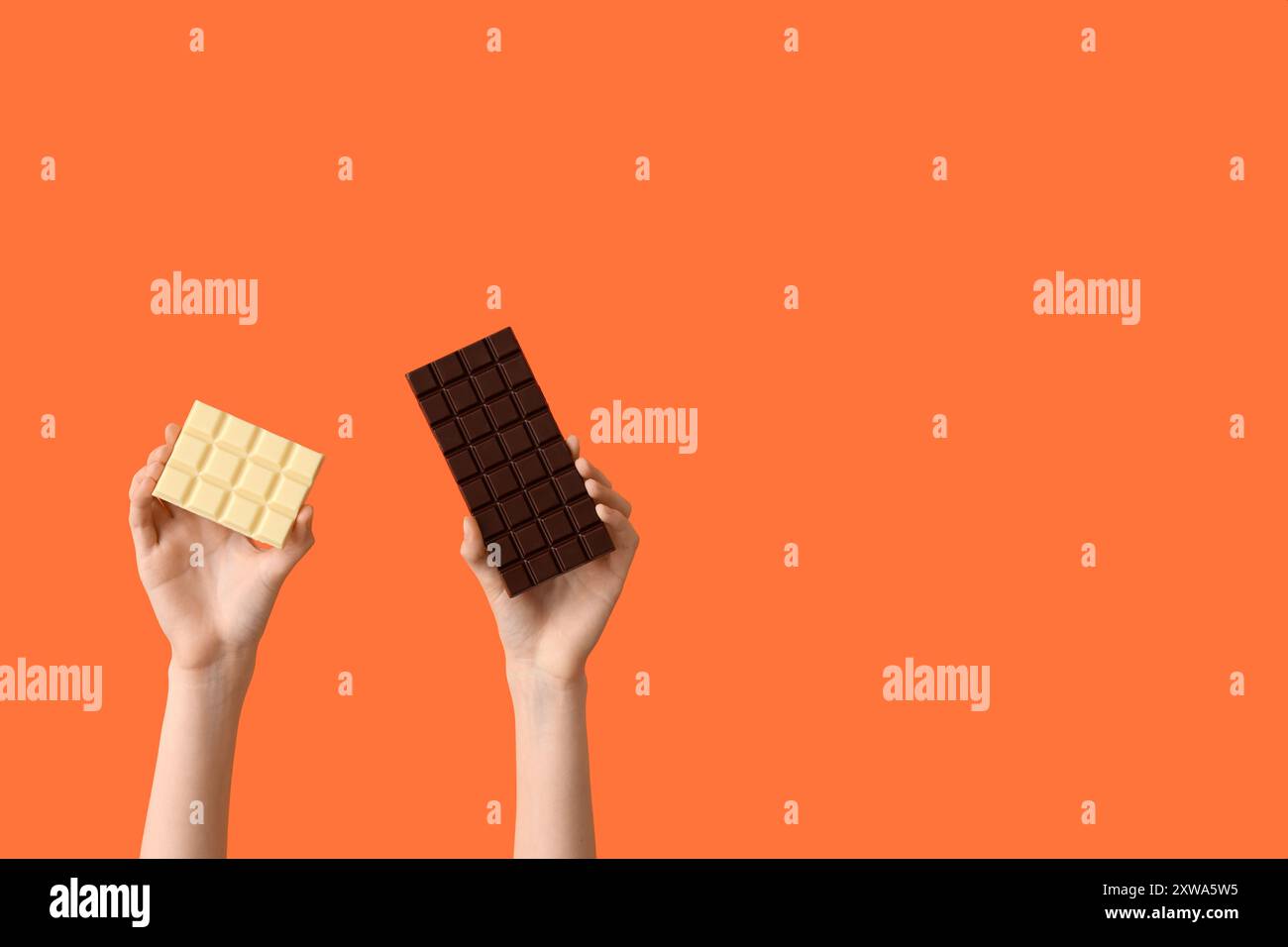 Female hands with different sweet chocolate bars on orange background ...