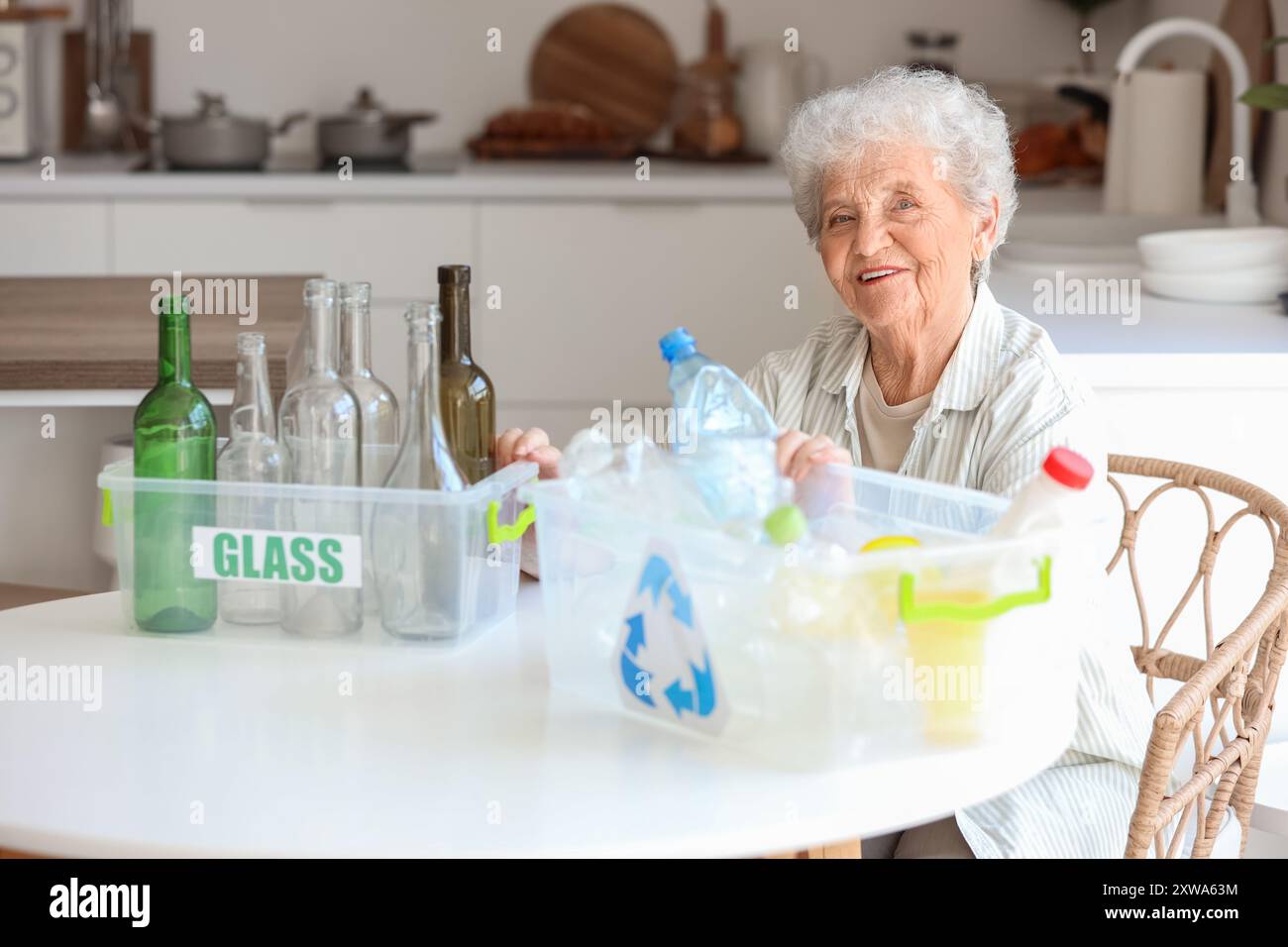 Senior woman with containers of garbage at table in kitchen. Waste ...