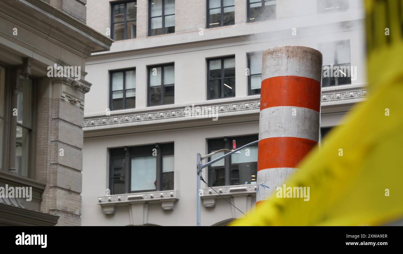 Steam vapor vented on New York City street, orange vapour tube stack ...