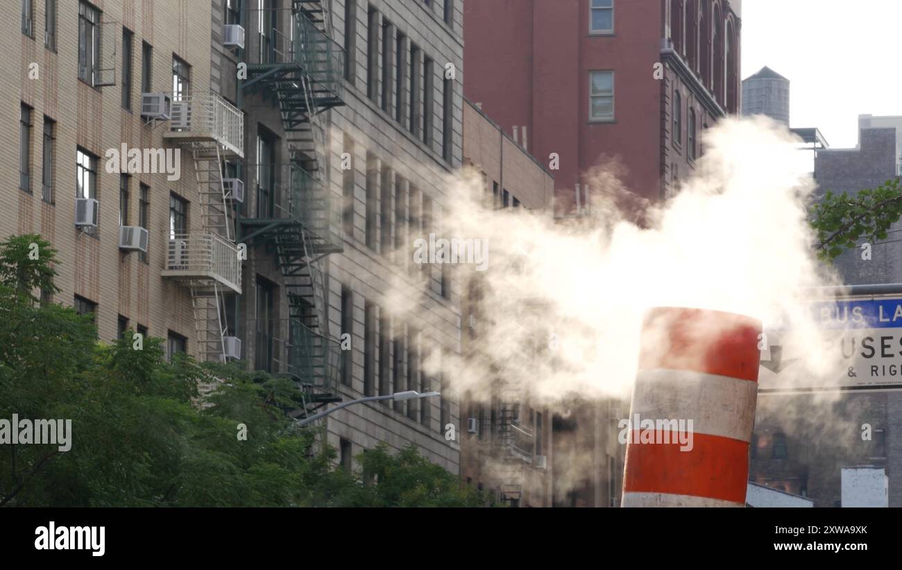 Steam vapor vented on New York City street, orange vapour tube stack ...