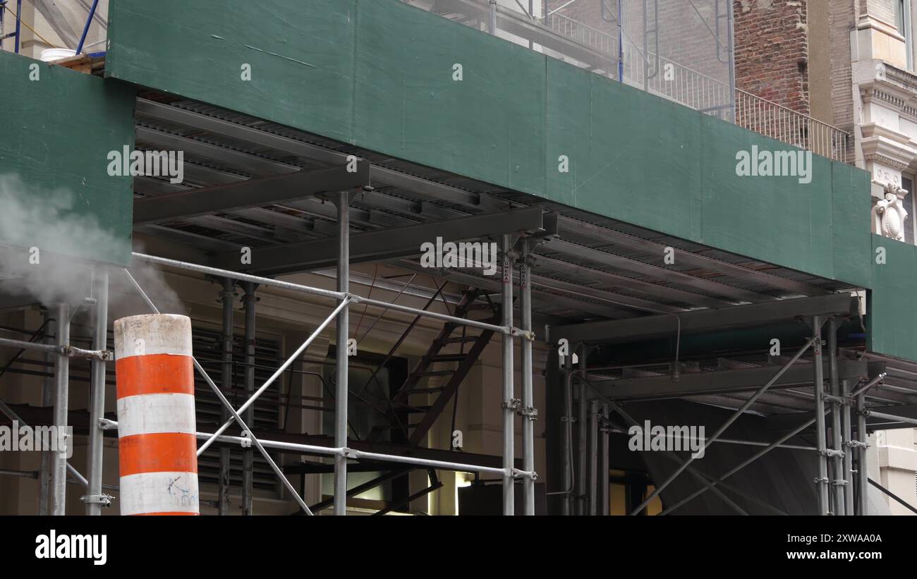 Steam vapor vented on New York City street, orange vapour tube stack ...