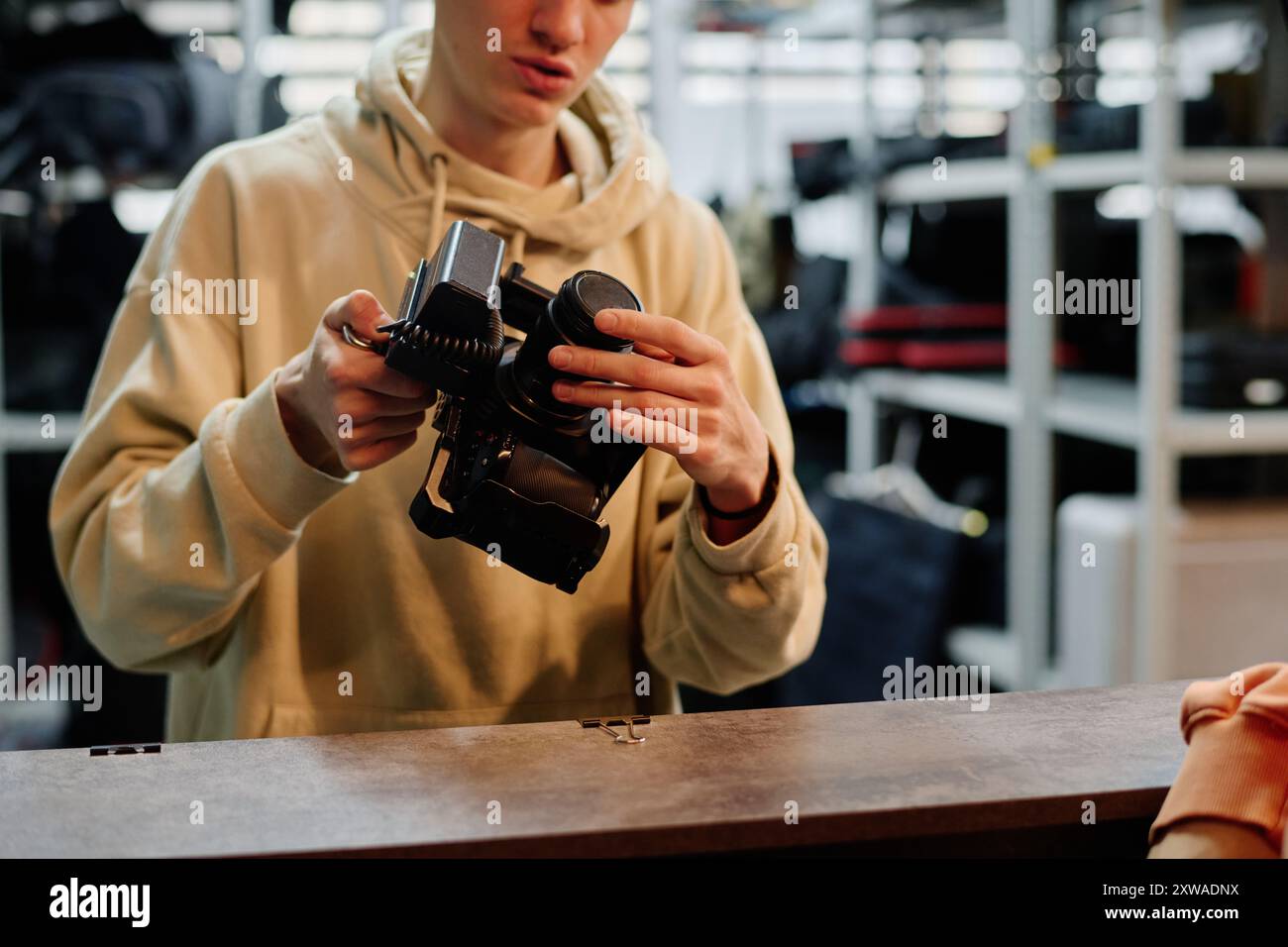 Individual assembling camera in studio with various equipment in background capturing process ...