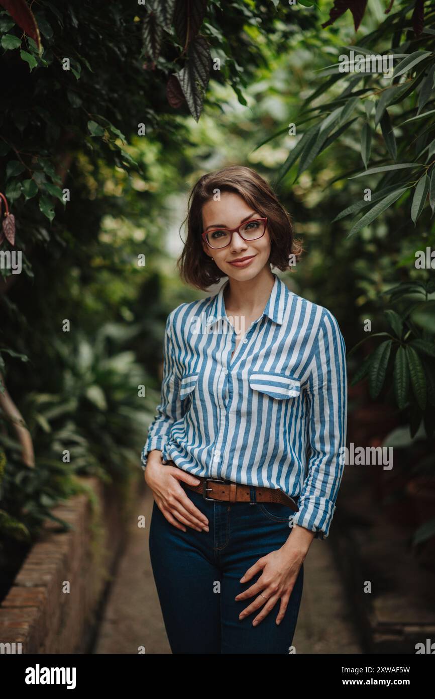 Beautiful woman standing in botanical garden, in the middle of lush ...