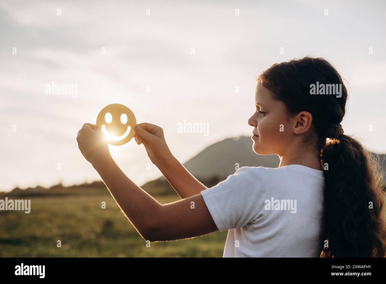 Selective focus of cute girl child holding yellow happy smile face on ...