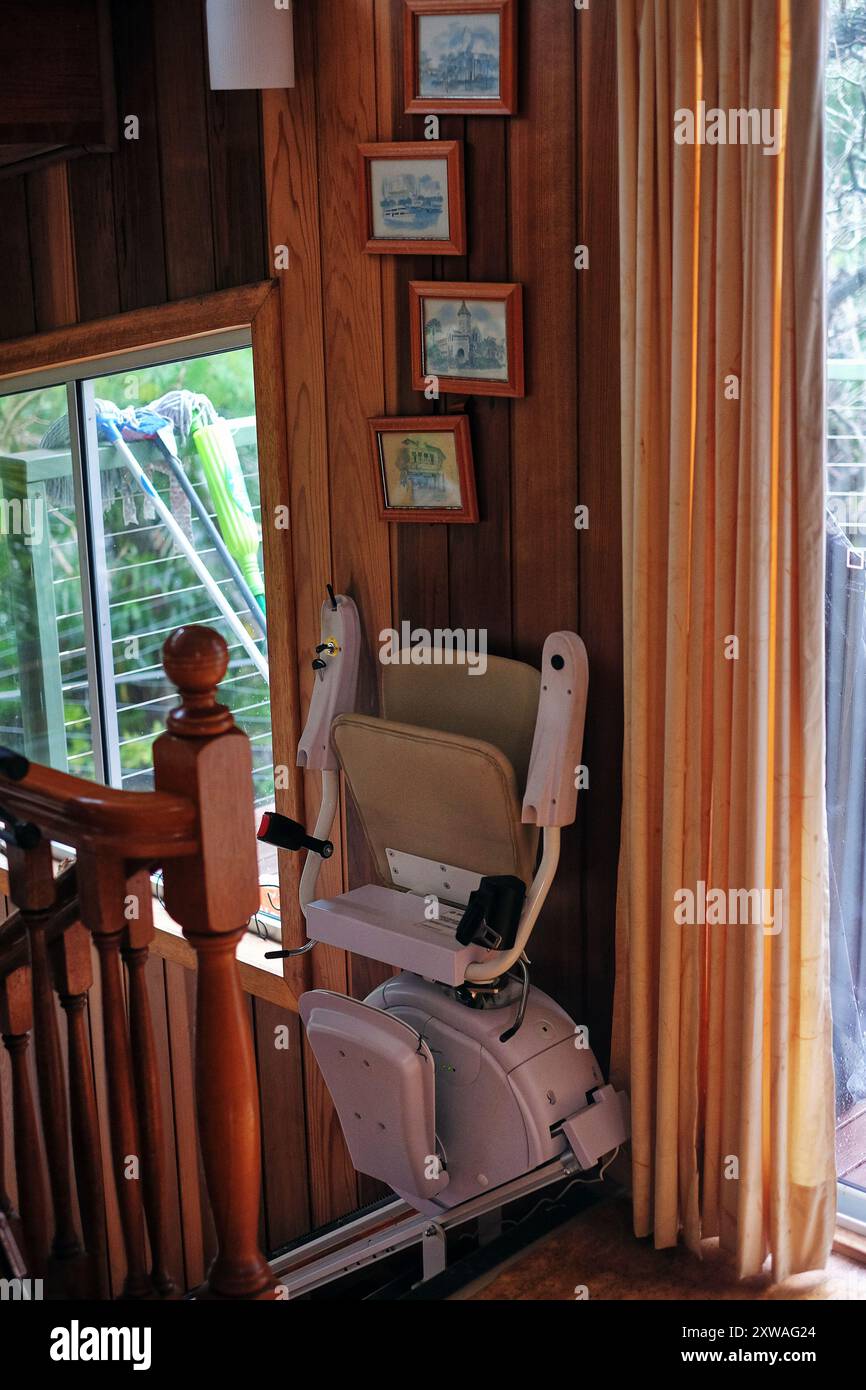 Stairlift, chair-lift chair folded at the at the top of the steps ...