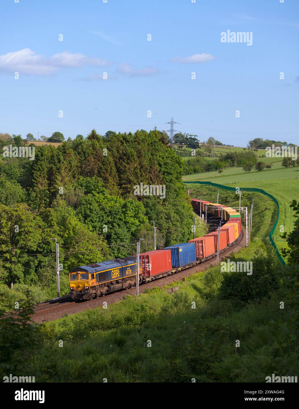 GB Rail Freight 66 diesel locomotive on the west coast main line with an intermodal container ...