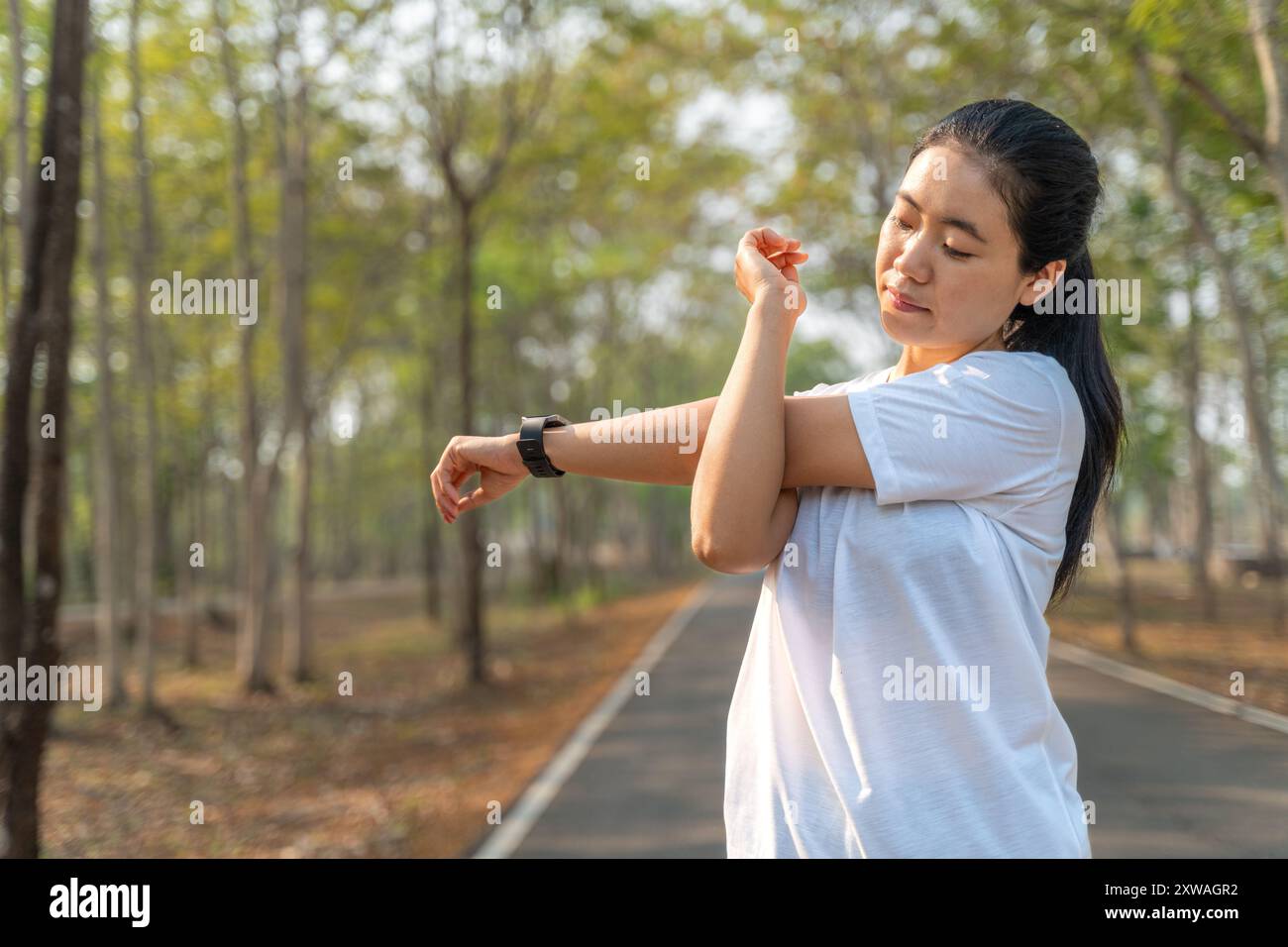 Young female runner stretching her arms and legs before starting her ...
