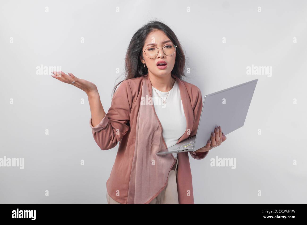 Confused Asian business woman holding laptop thinking about stressing ...