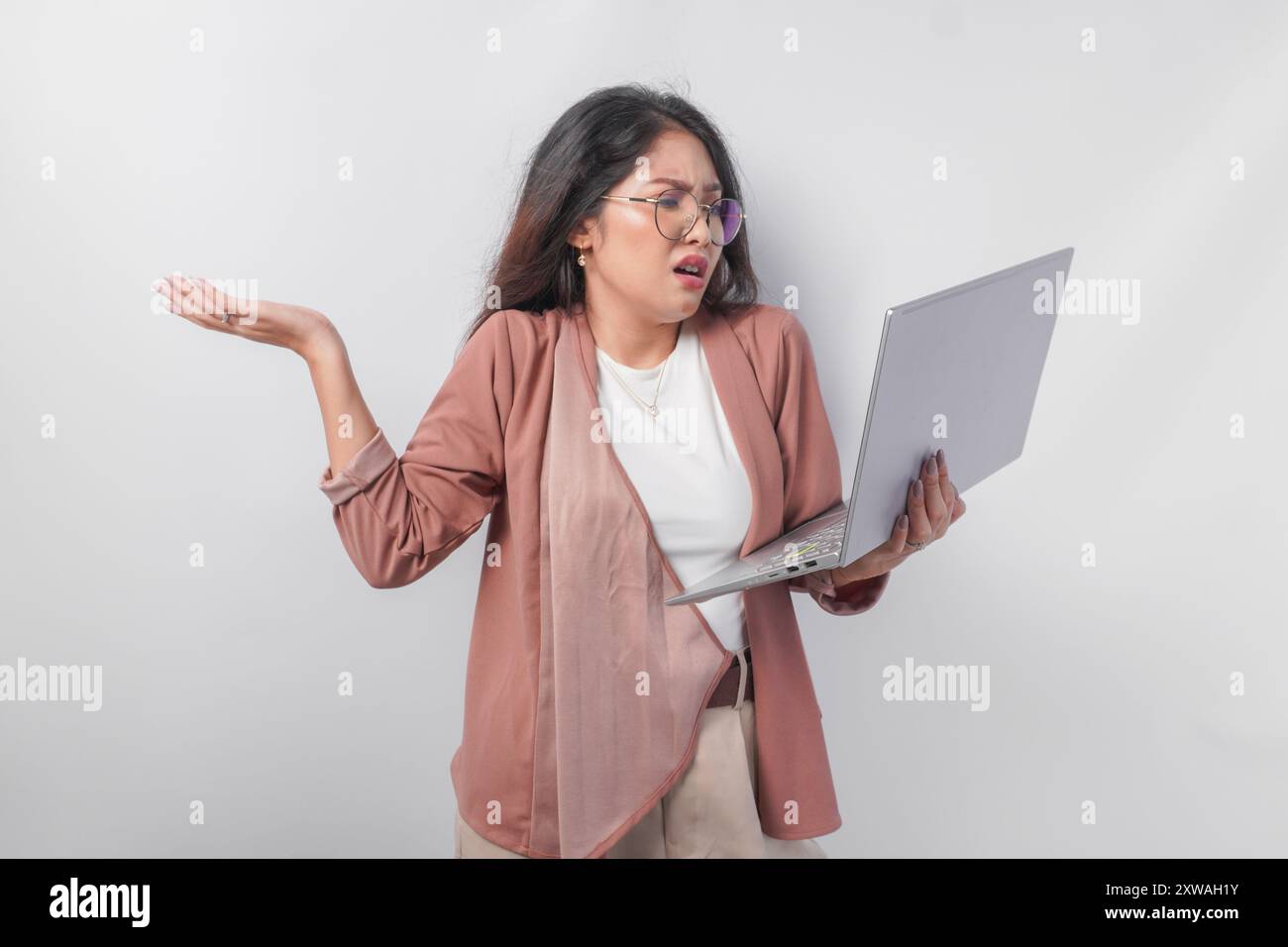 Confused Asian business woman holding laptop thinking about stressing ...