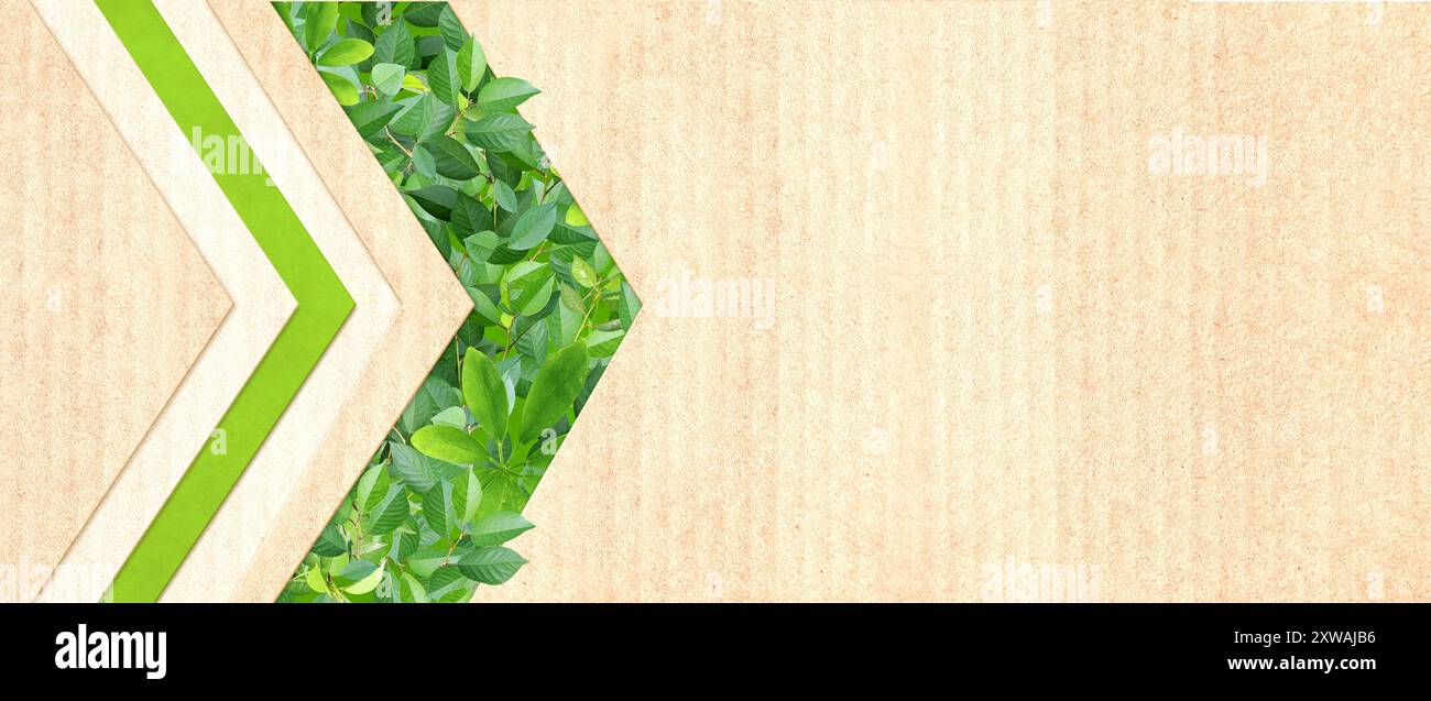 Green leaves and arrow symbol on recycled cardboard texture ...
