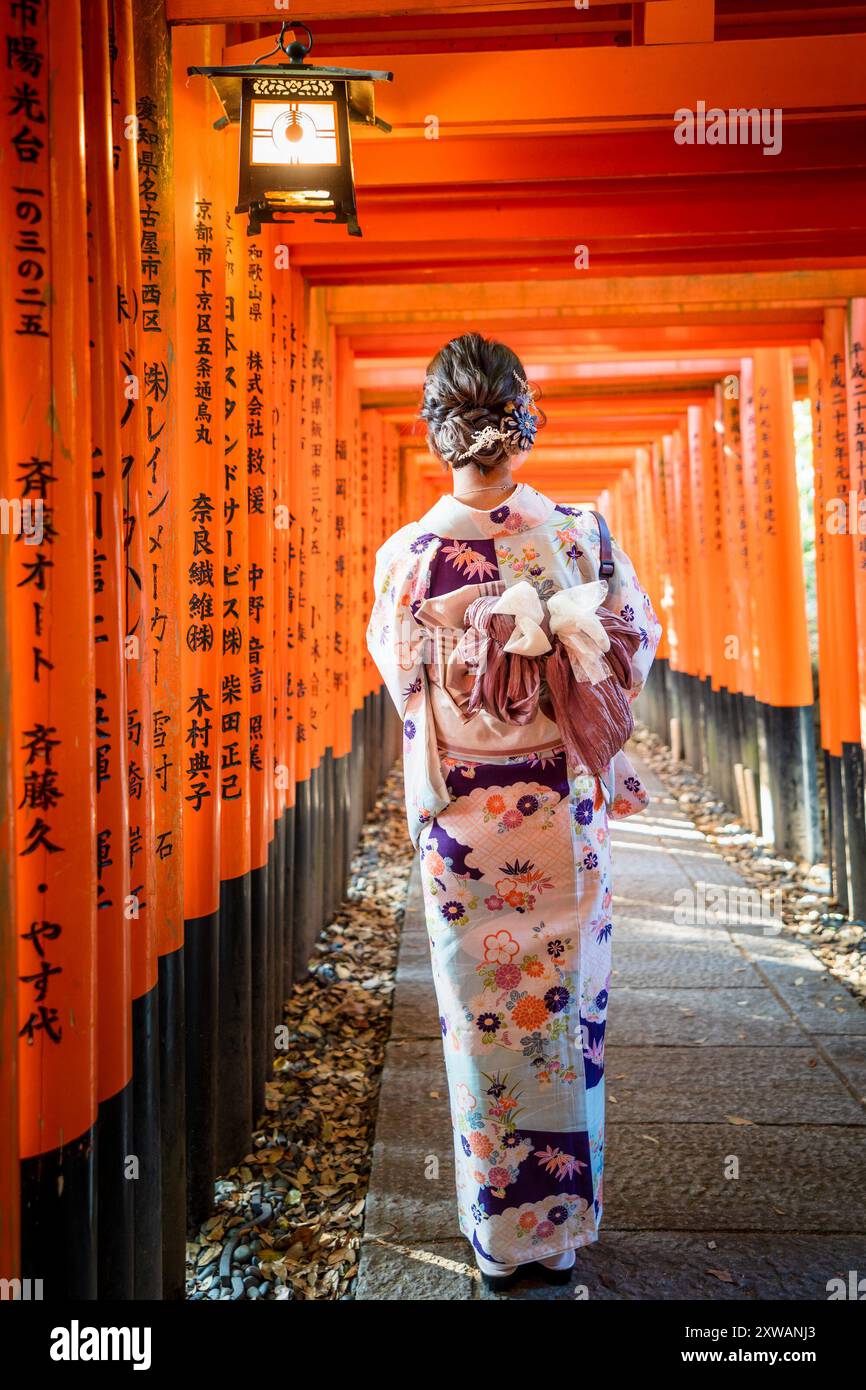 A woman in kimono walking in Fushimi Inari Taisha shrine Senbon Torii ...