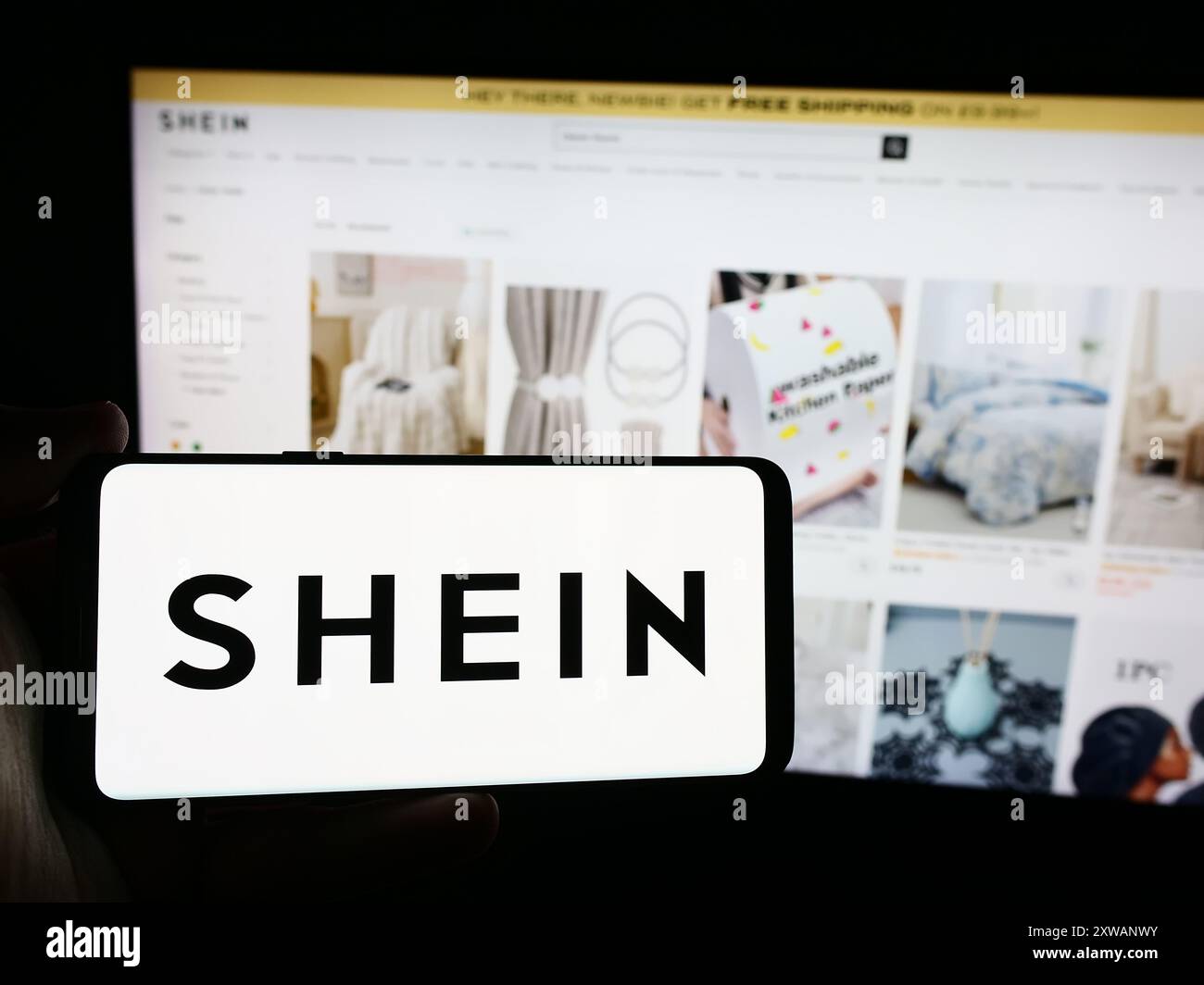 Person holding smartphone with logo of fashion e-commerce company Shein ...