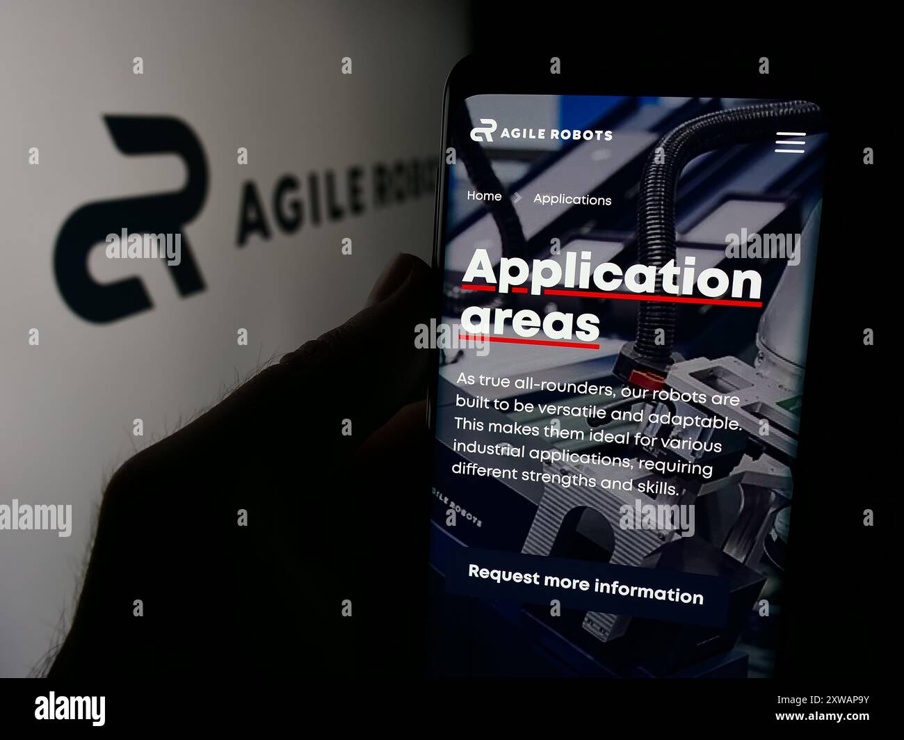 Person holding cellphone with webpage of German robotics company Agile ...