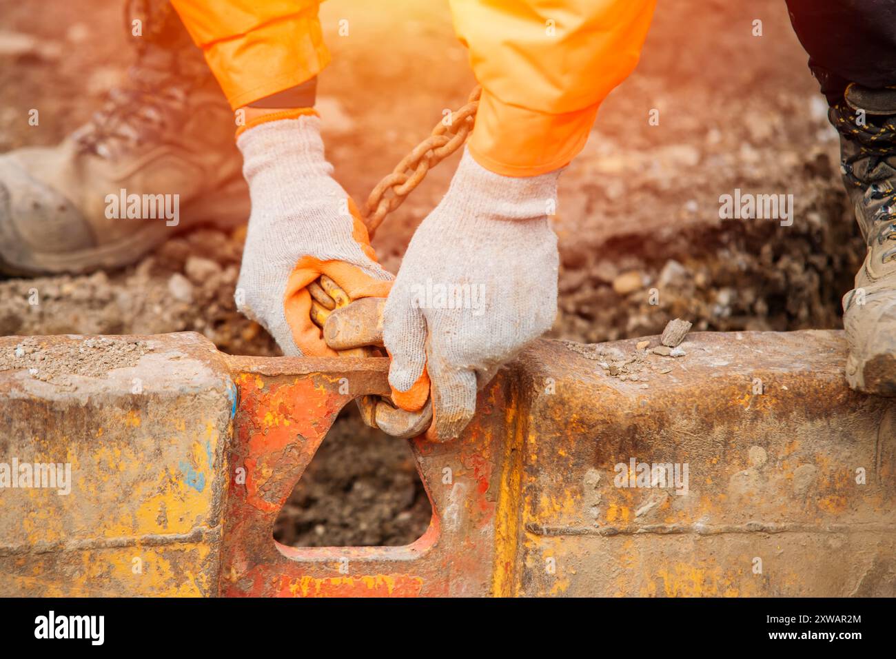 Builder attaching fixing lifting gear hook and chain to safety shore ...