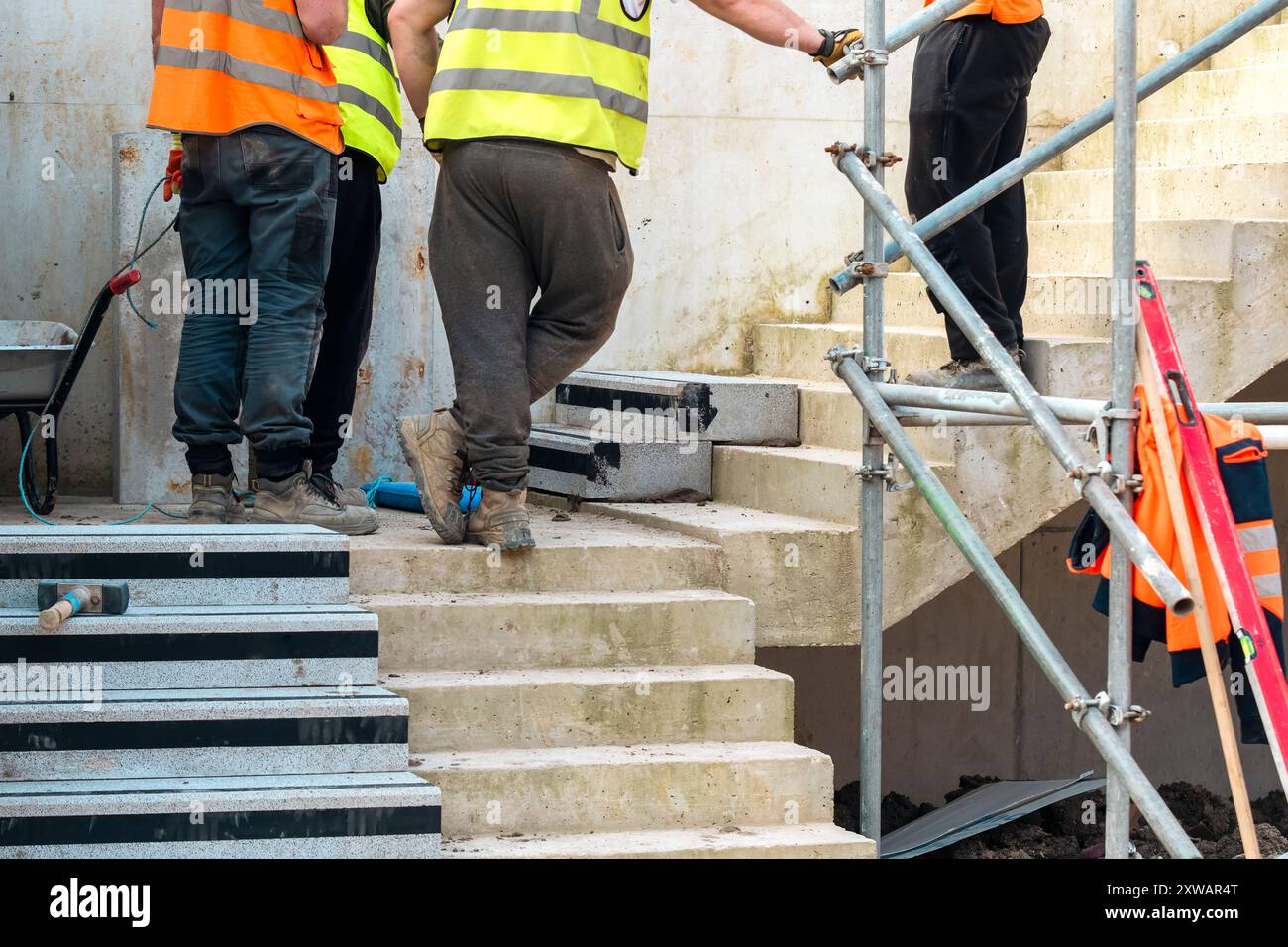 Concrete steps under construction as a team of builders install heavy ...