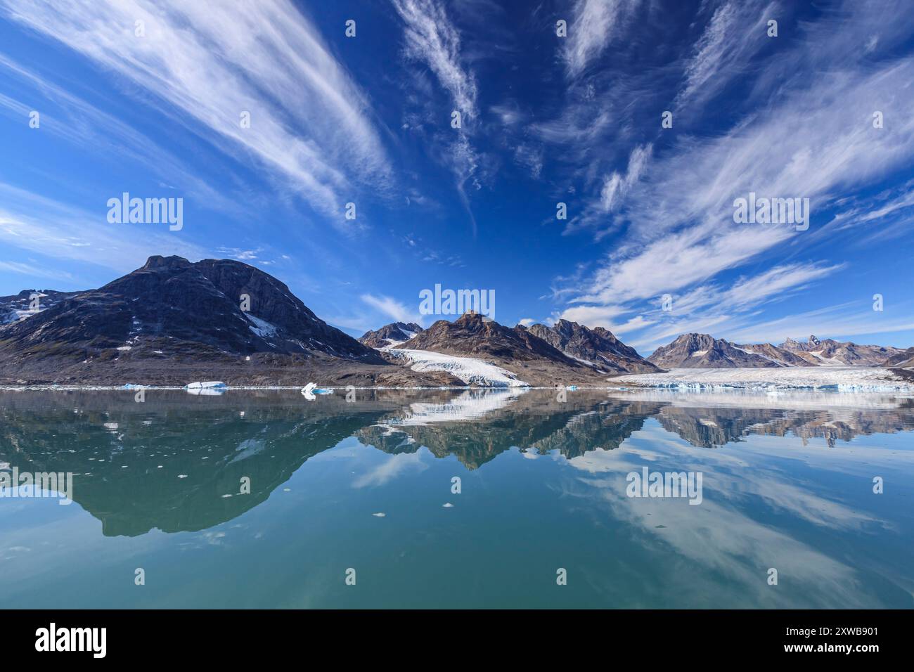 Reflection of Glacier, icebergs and mountains in a remote fjord, East ...