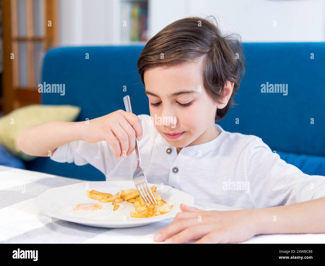 Boy eating meal at table Stock Photo - Alamy