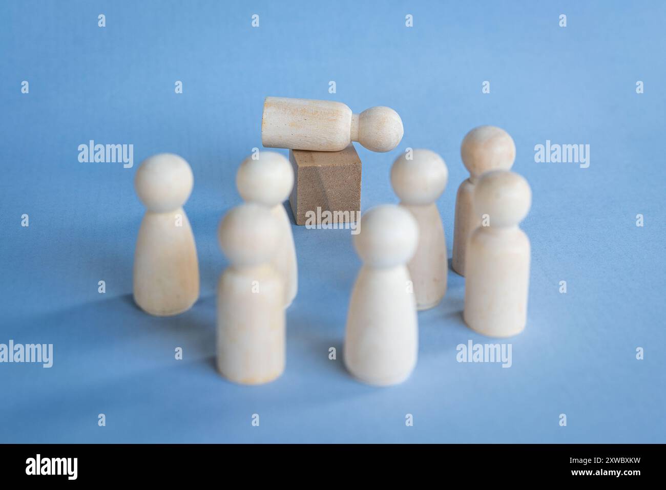 People figures or toy blocks with one lying down on podium. Failure or ...