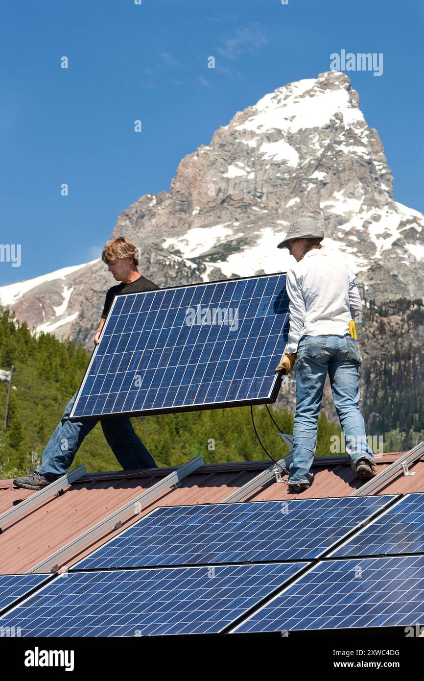 A man and a woman perform an installation of a photovoltaic panel at ...