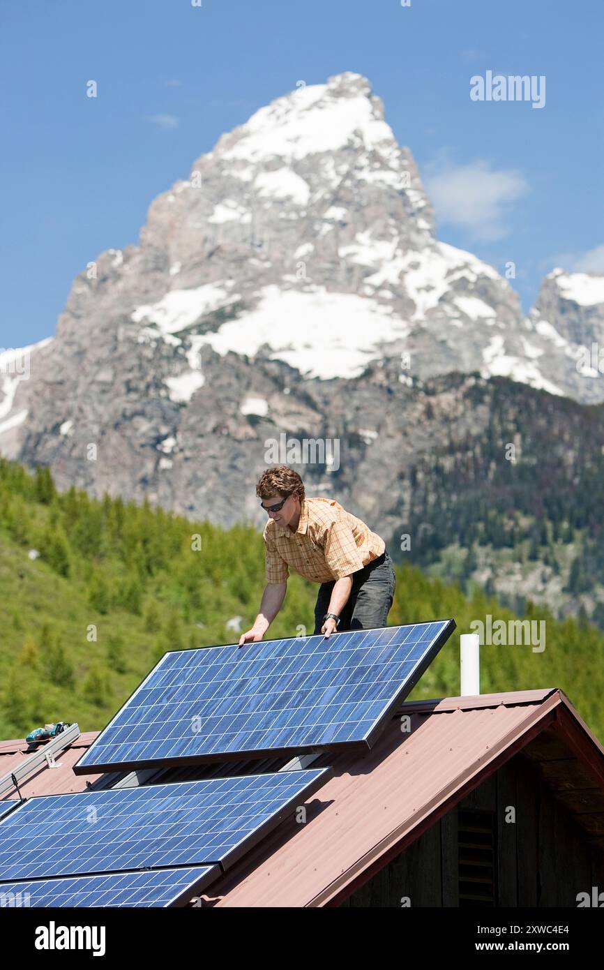 A man performs an installation of a photovoltaic panel at the Grand ...