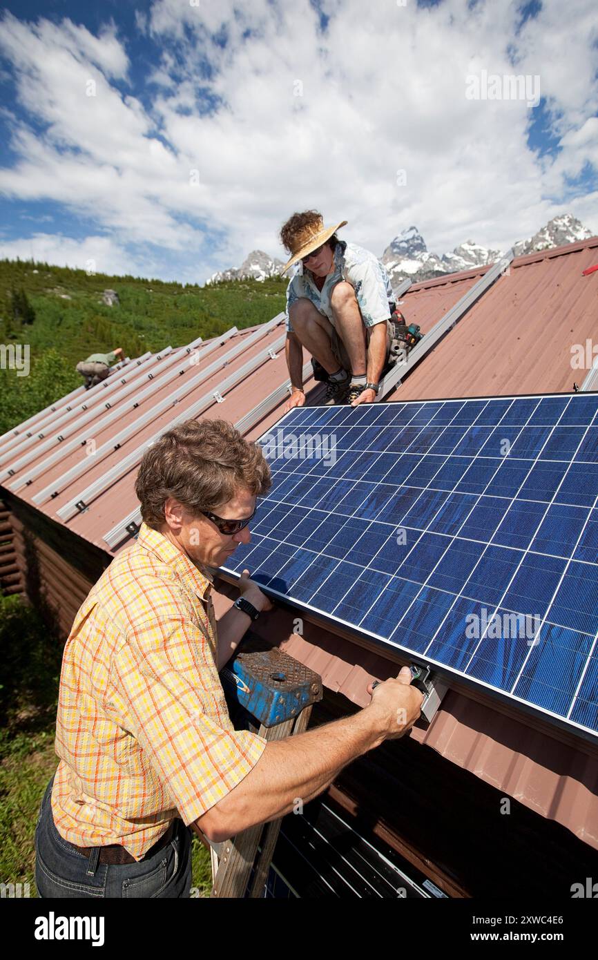 Two people perform an installation of a photovoltaic panel at the Grand ...
