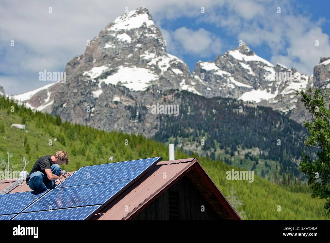 A man performs an installation of a photovoltaic panel at the Grand ...