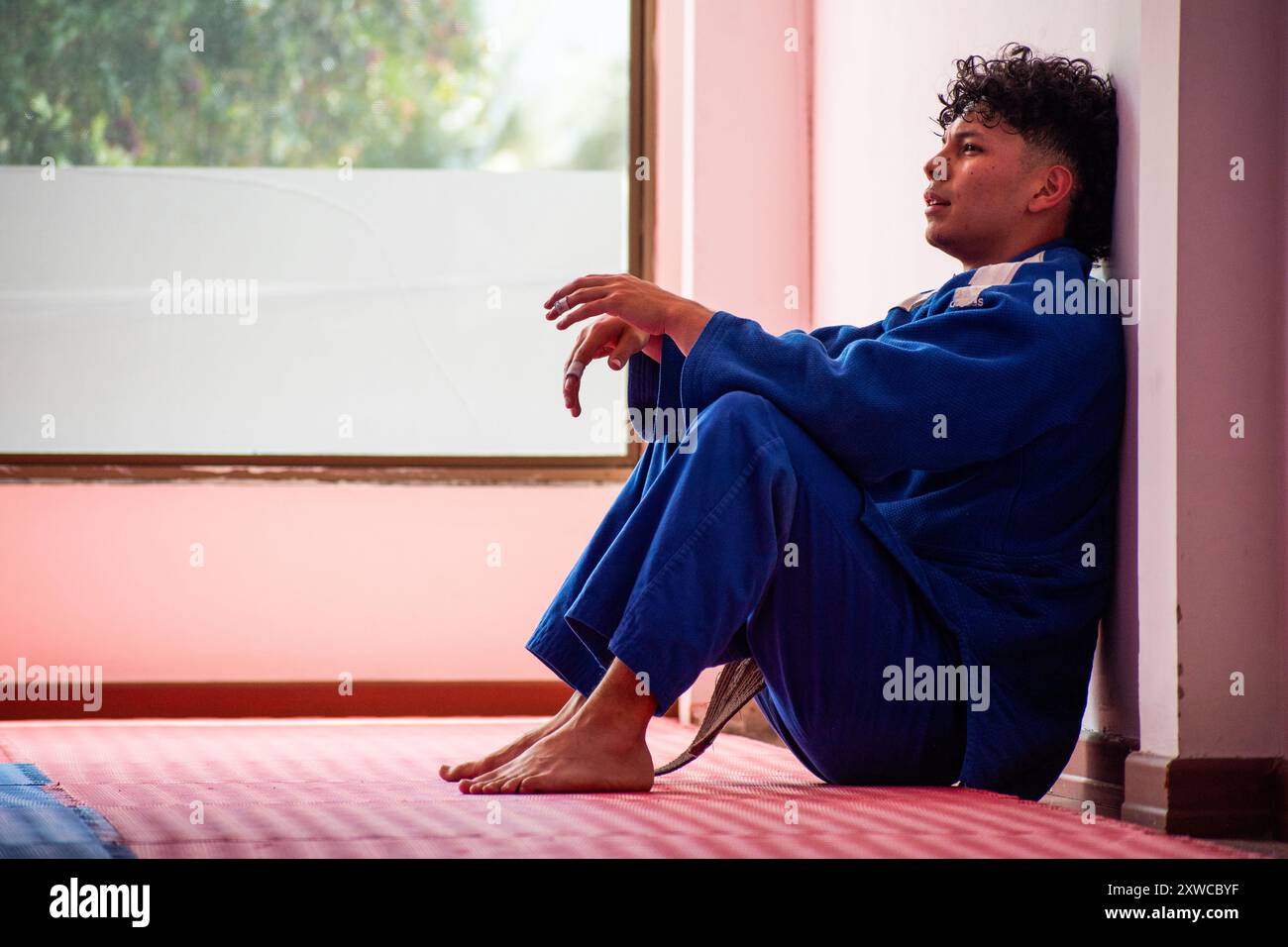 Judo fighter portrait resting in dojo with some trees at background ...