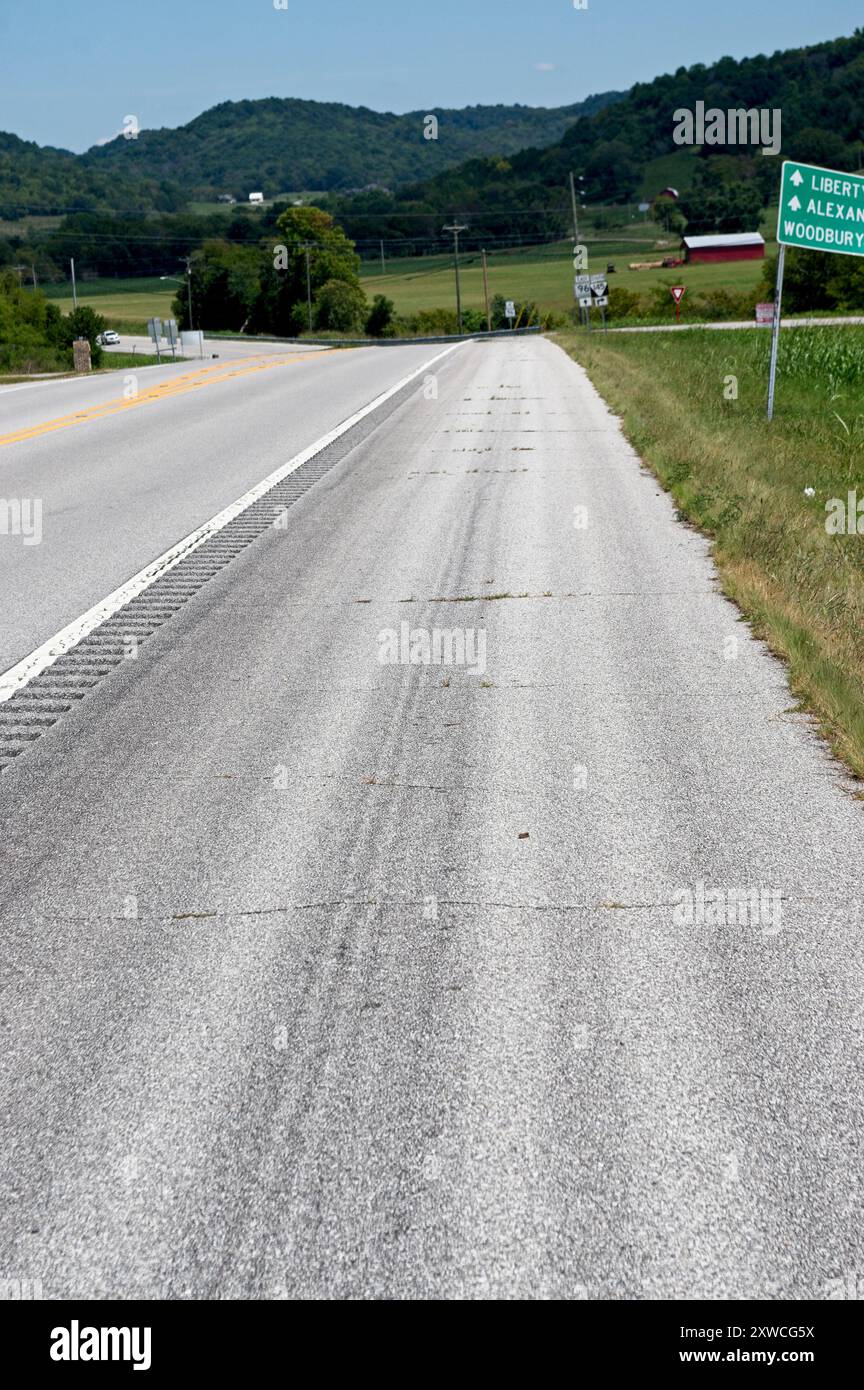 Road shoulder on a rural highway with directional sign and rumble strip ...